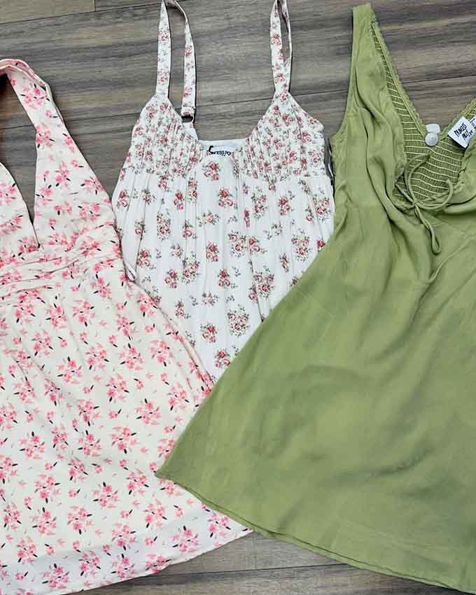 Floral dresses hanging like a garden of possibilities, each one ready for its second chance at summer romance.