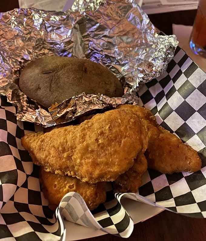 Crispy chicken tenders with a foil-wrapped potato, comfort food that hits all the right nostalgic notes.
