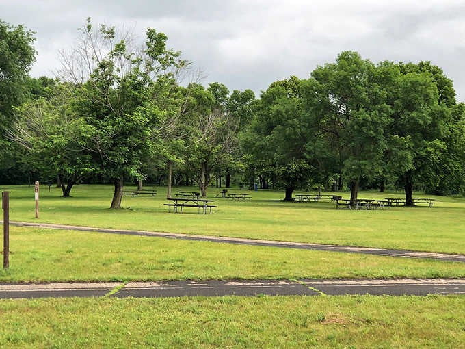 Picnic tables scattered under shade trees, ready for sandwiches that somehow taste gourmet when eaten outdoors.