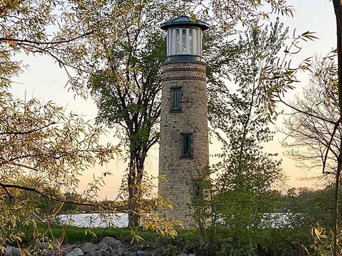 Framed by autumn branches, this cream brick tower stands like a patient grandfather watching over generations of shoreline memories.