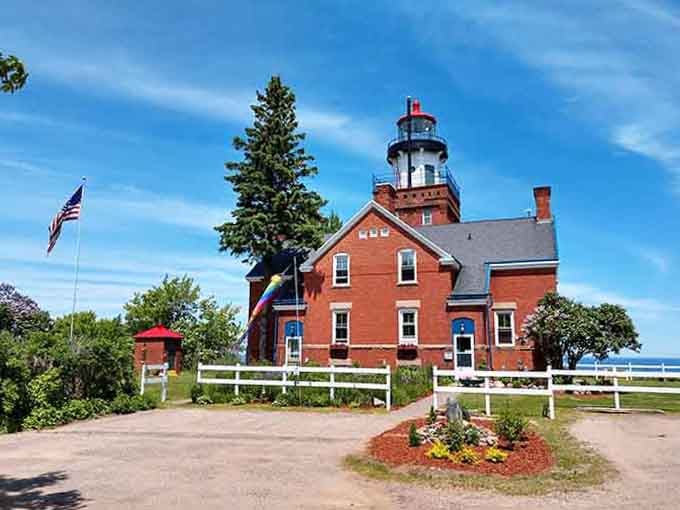 The white picket fence and brick building create a scene straight from a Norman Rockwell painting.