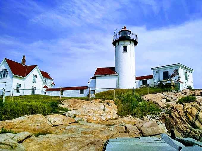 Rocky outcrops frame the white tower and its charming red-roofed companions, nature's perfect landscaping at work.