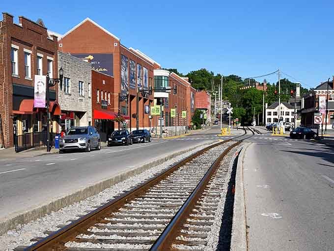 Railroad tracks slice through downtown like a steel ribbon, turning everyday commerce into an unexpected adventure for visitors.
