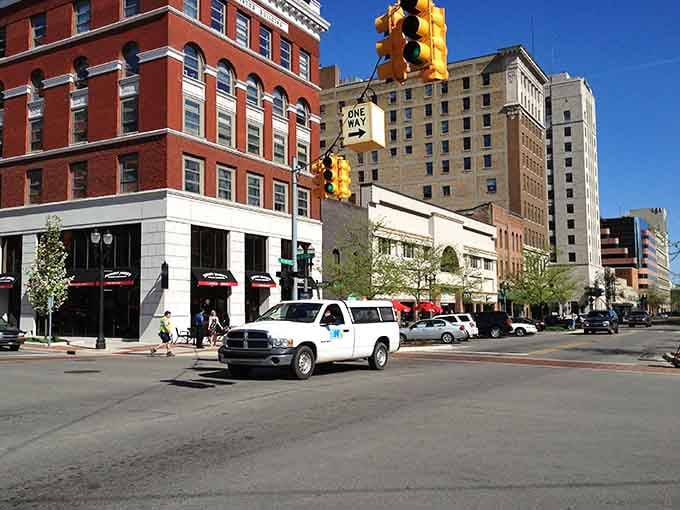 Classic red brick buildings catch the sunlight while yellow traffic signals guide you through streets that won't drain your savings.