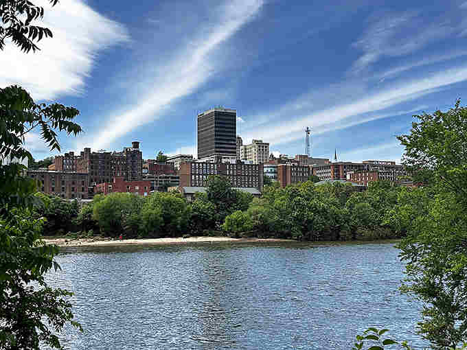 The James River sparkles beyond industrial buildings that tell stories of manufacturing days transformed into riverside living.