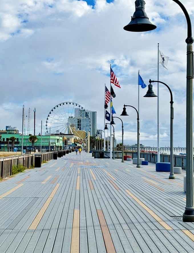 The boardwalk stretches toward the ocean with flags waving proudly, inviting you to stroll and breathe that salty air.
