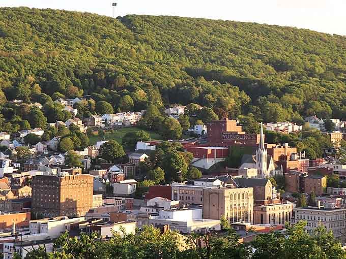 Green mountains cascade down to meet rooftops in layers that look like a Bob Ross painting come to life.