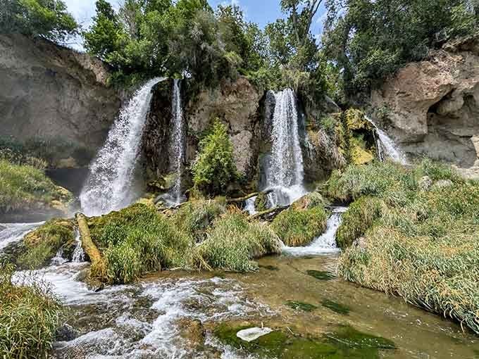 Three waterfalls cascade side by side over moss-covered rocks, creating nature's own triple-feature spectacular.