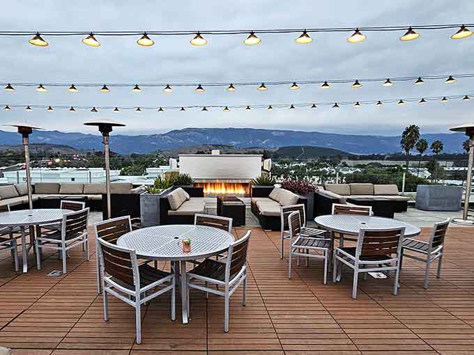 String lights crisscross overhead like stars you can actually reach while mountains fade into dusk.