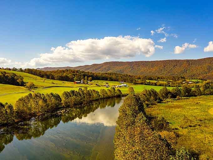 The winding river reflects autumn's brilliant palette, creating a double dose of nature's most spectacular show.