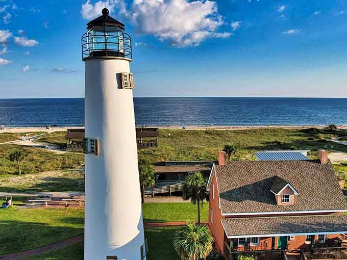 This elevated perspective shows the tower rising above keeper's quarters, a complete picture of lighthouse life by the Gulf waters.