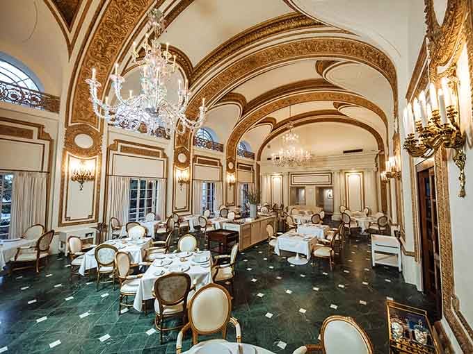 Crystal chandeliers illuminate gilded arches in a dining room so opulent it rivals any Parisian palace ballroom.