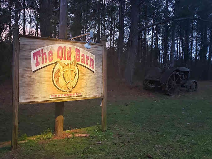 As twilight settles, The Old Barn's rustic sign and vintage tractor set the stage for country dining perfection.