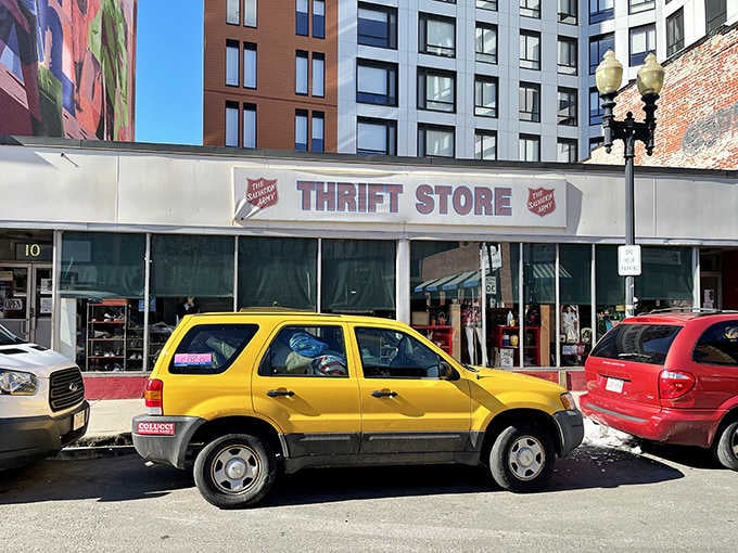 The bright yellow SUV parked outside adds a splash of color to this urban thrift shopping scene.