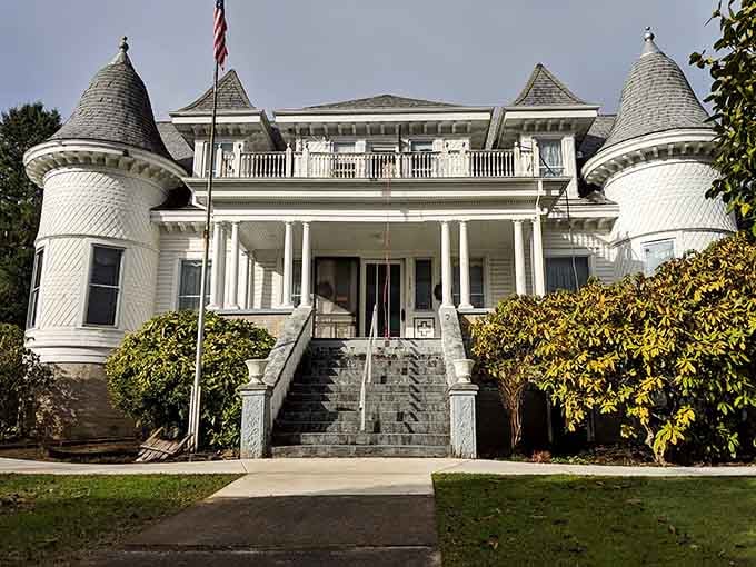 Twin turrets flank this Victorian showstopper like castle towers, all white clapboard elegance and architectural ambition on full display.