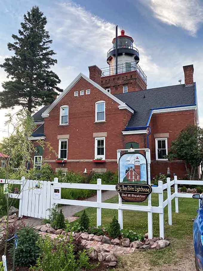 Evening light softens the brick facade, making this lighthouse look like a cozy home you'd never leave.