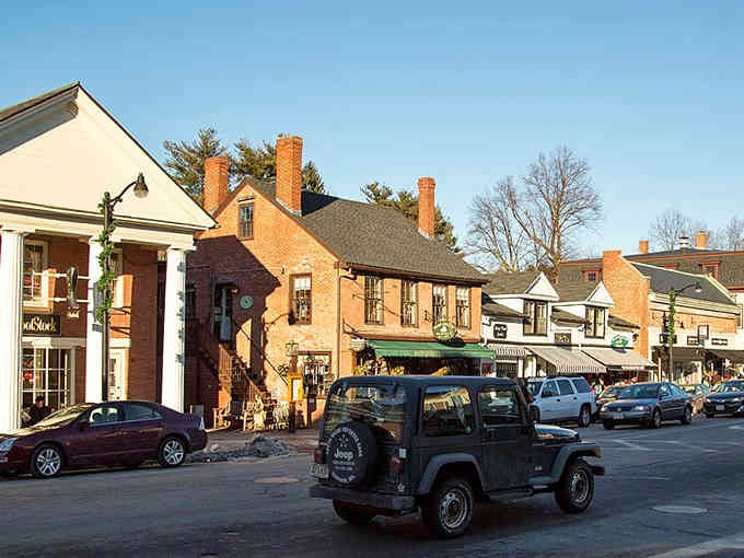 Golden hour bathes these historic storefronts in warm light as daily life unfolds along the bustling street.