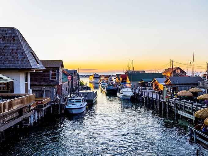 That sunset paints the fishing shanties and docked boats in golden light, creating pure waterfront magic before your eyes.