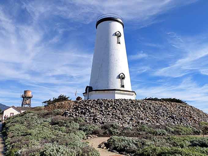 Standing sentinel on its rocky hill, this lighthouse rises clean and simple against the coastal scrubland like minimalist perfection.