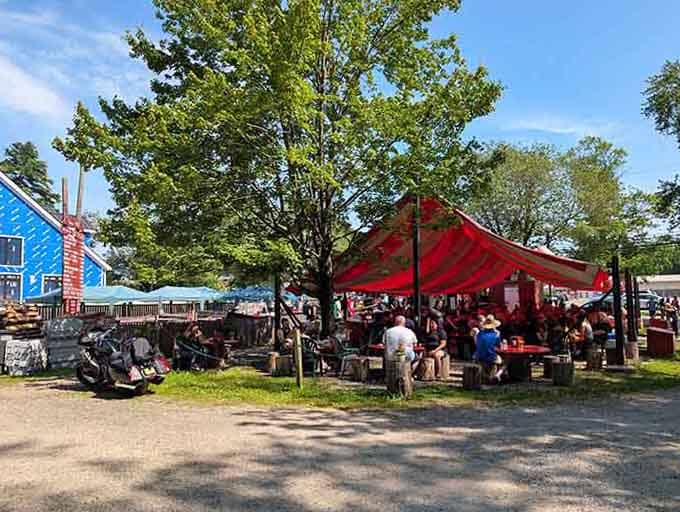 Under those festive red tents, families gather around communal tables sharing stories and smoky grilled treasures from the sea.