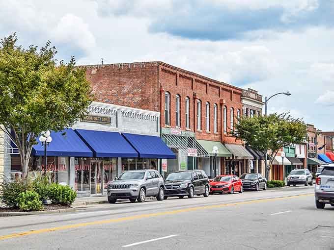 Classic brick storefronts and blue awnings prove small-town charm doesn't require a Hollywood budget or trust fund.