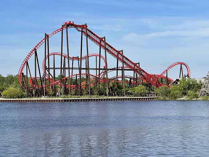 The stunning red roller coaster tracks twist and turn above the water, creating an unforgettable skyline at Michigan's Adventure in Muskegon.