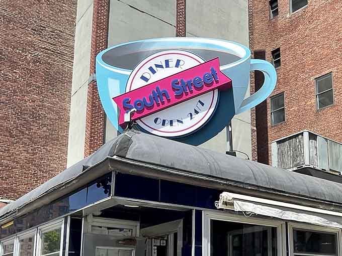 That iconic coffee cup sign glowing against the Boston skyline is your beacon of hope at any hour.