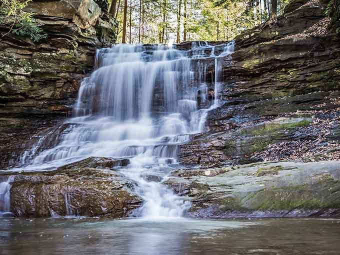 Water cascading over ancient stone like nature's own private show, just waiting for you to discover it.