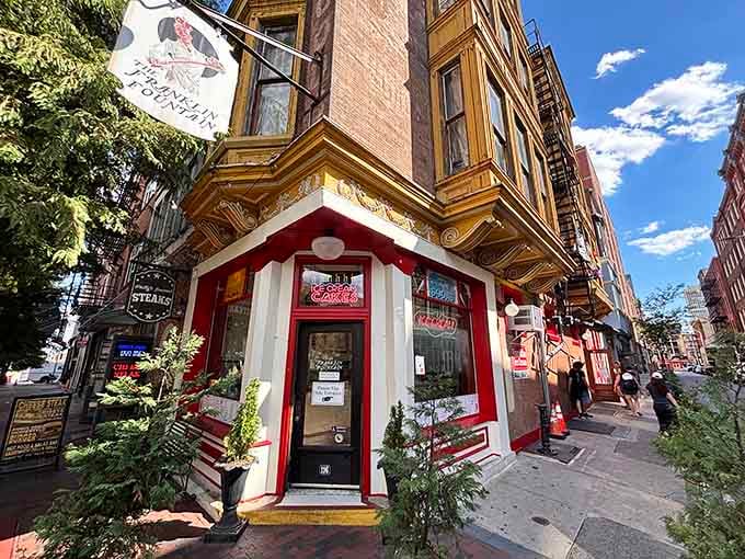 That charming red and white corner storefront looks like it stepped right out of a postcard from 1900.