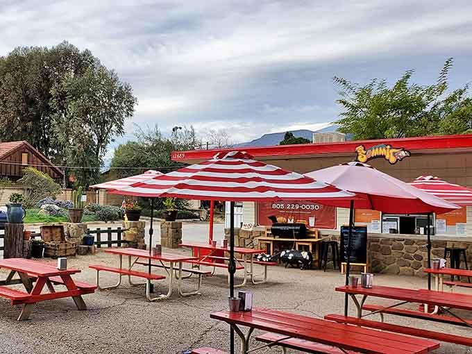 That cheerful red building against the mountain backdrop is your destination for burger bliss and milkshake magic.