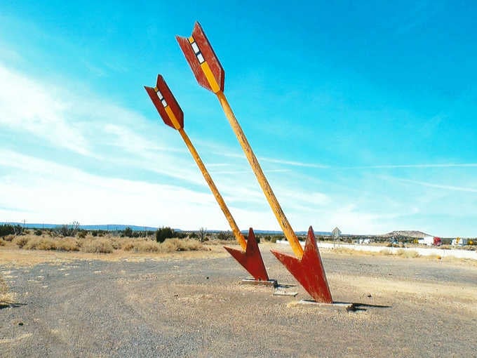 The twin arrows lean dramatically, as if frozen mid-flight toward some distant desert target only they know.