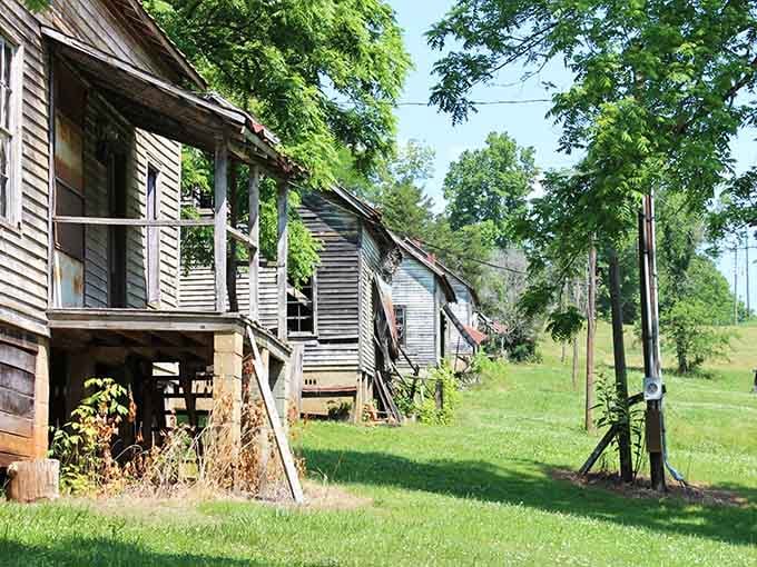 Sunlight filters through lush green trees, guiding you past weather-worn wooden cottages that whisper stories of a bygone industrial era.