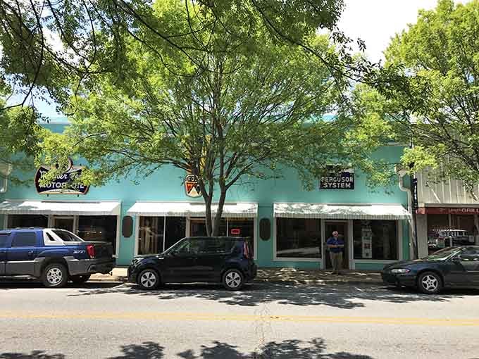 That turquoise storefront under the shade trees proves small-town charm doesn't need a filter to shine beautifully.