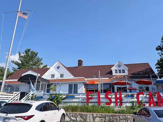 That white cottage exterior with the red roof isn't trying to impress anyone, and that's exactly why it works perfectly.