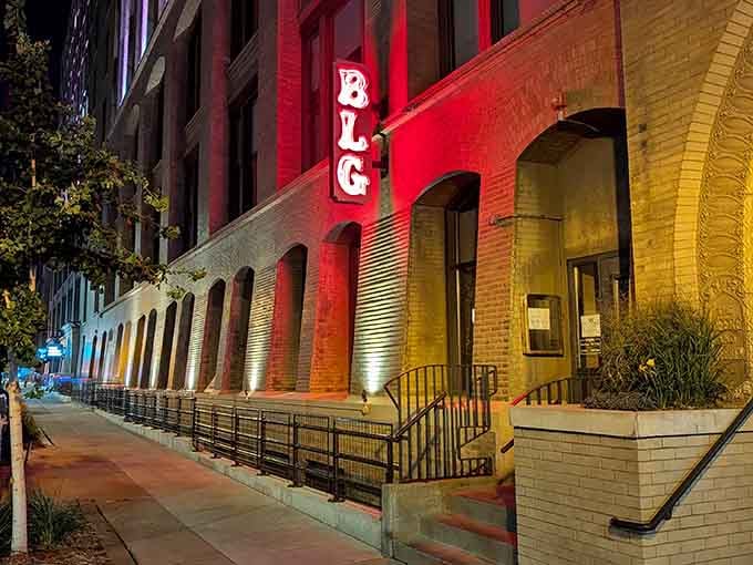 Dramatic uplighting transforms historic brick into a canvas of color, announcing that exceptional pasta awaits just beyond those doors.