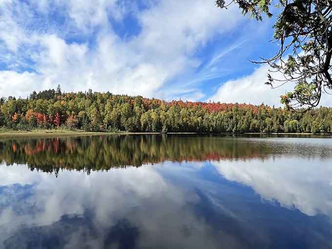 The lake's mirror-perfect surface doubles the autumn color show, proving that nature loves a good two-for-one deal.