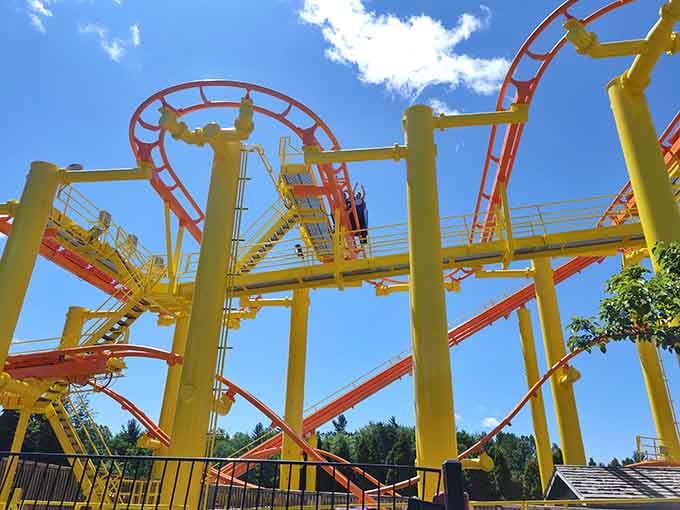 Bright yellow supports frame this thrilling coaster against blue skies, promising excitement and adventure for riders brave enough to take on the challenge.