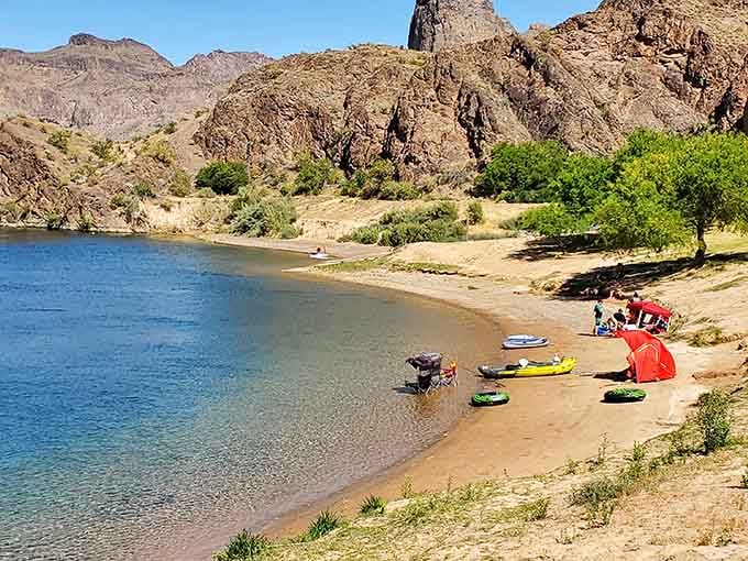 That perfect little beach where kayaks rest and families claim their sandy kingdoms for the day's aquatic adventures.