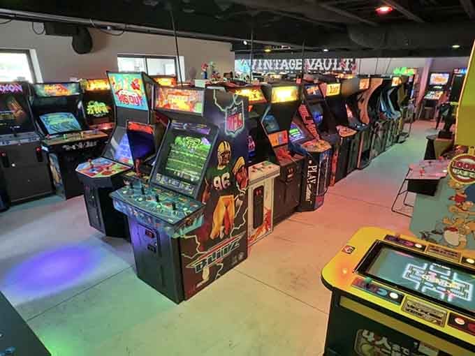 Rows of glowing cabinets stand ready like soldiers of joy, each one promising a different adventure into gaming's golden age.