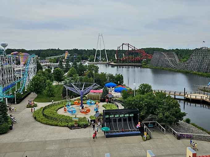 An aerial view showcases the sprawling park layout, with colorful rides, peaceful waterways, and Camp Snoopy nestled among the trees and attractions.