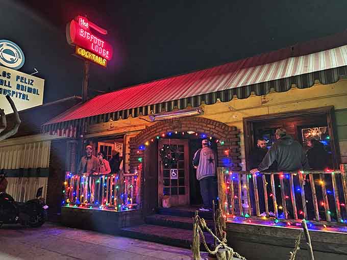 That glowing neon sign beckons like a lighthouse for the thirsty, promising woodland adventures and excellent cocktails ahead.