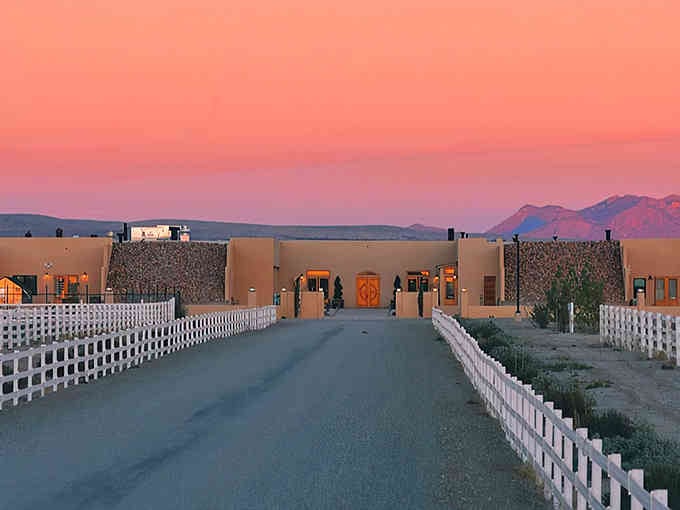 That white picket fence leading to Southwestern architecture under cotton candy skies looks like a movie set.