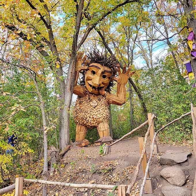 This cheerful wooden troll waves hello, proving that Minnesota's idea of public art involves serious whimsy and craftsmanship.