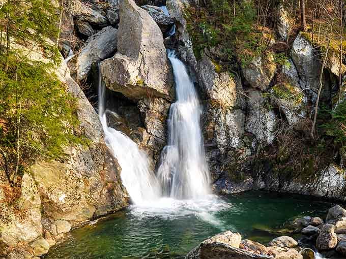 Water splitting around ancient boulders like it's been rehearsing this performance for millennia. Nature's showoff.