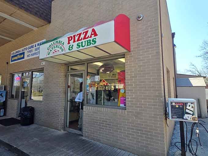 That cheerful red awning next to the gas pumps signals something special, where automotive services meet authentic pizza magic.