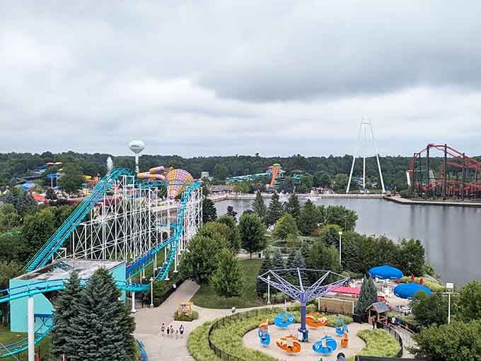 An aerial view showcases the sprawling park layout, with colorful rides, peaceful waterways, and Camp Snoopy nestled among the trees and attractions.