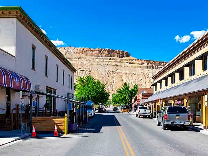 Main Street Palisade stretches beneath those magnificent cliffs like a postcard that somehow became real life.