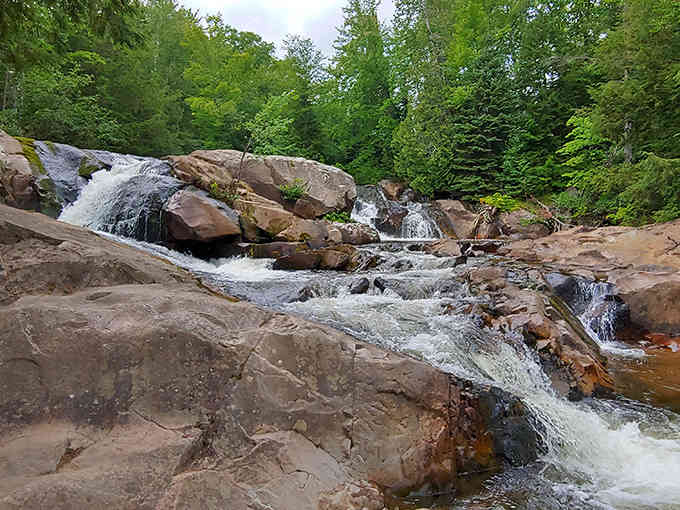 Nature's staircase in full glory, where water dances over rust-colored rocks like a liquid ballet performance.