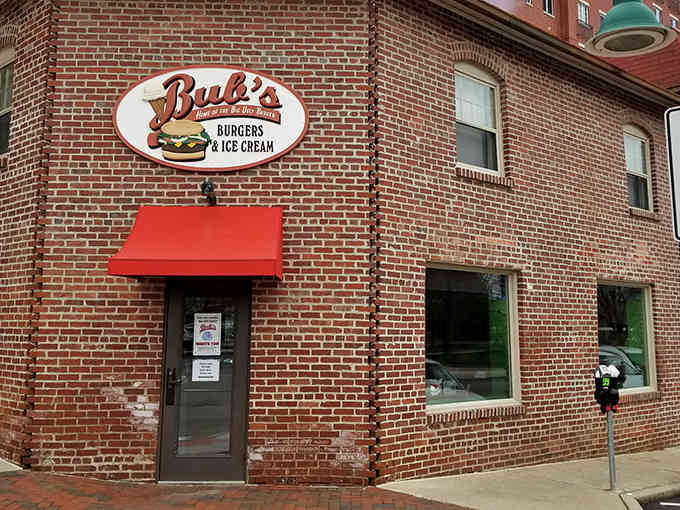That red awning beckons like a lighthouse for the hungry, promising salvation in burger form just beyond those brick walls.