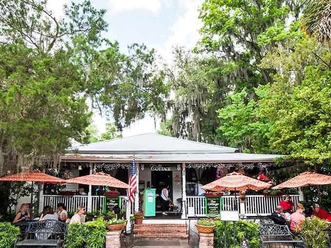 Spanish moss and red umbrellas create the kind of Southern charm that makes indoor dining feel like a mistake.